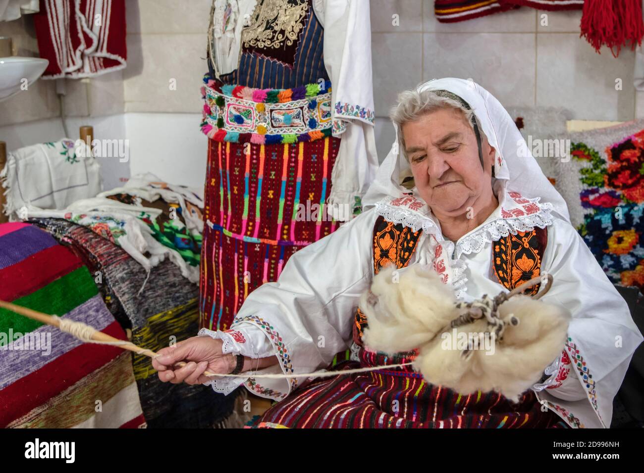 An old woman weaver spun wool on her hand. An old extinct craft Stock ...