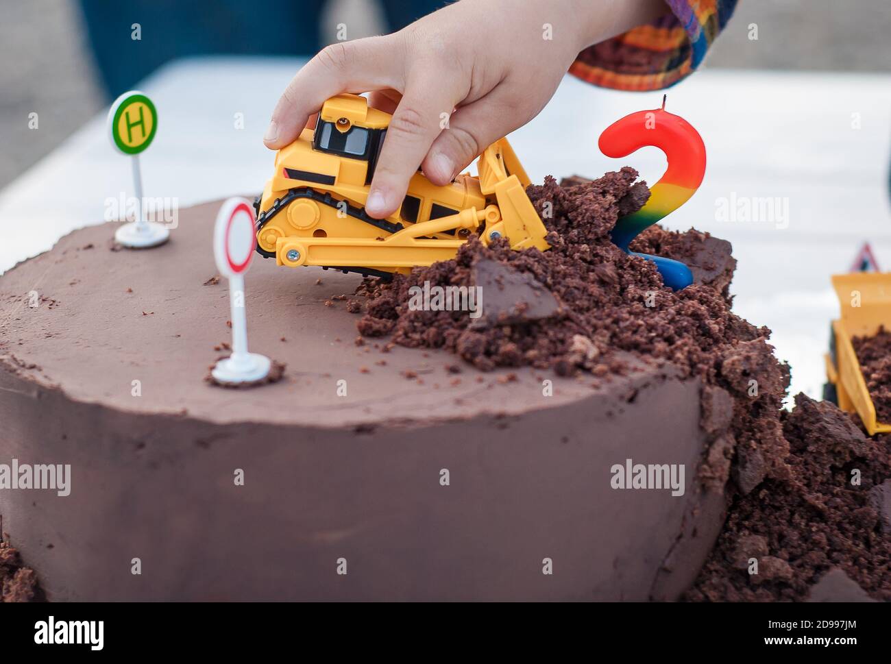 Birthday chocolate cake with bulldozer toy and children hand Stock ...