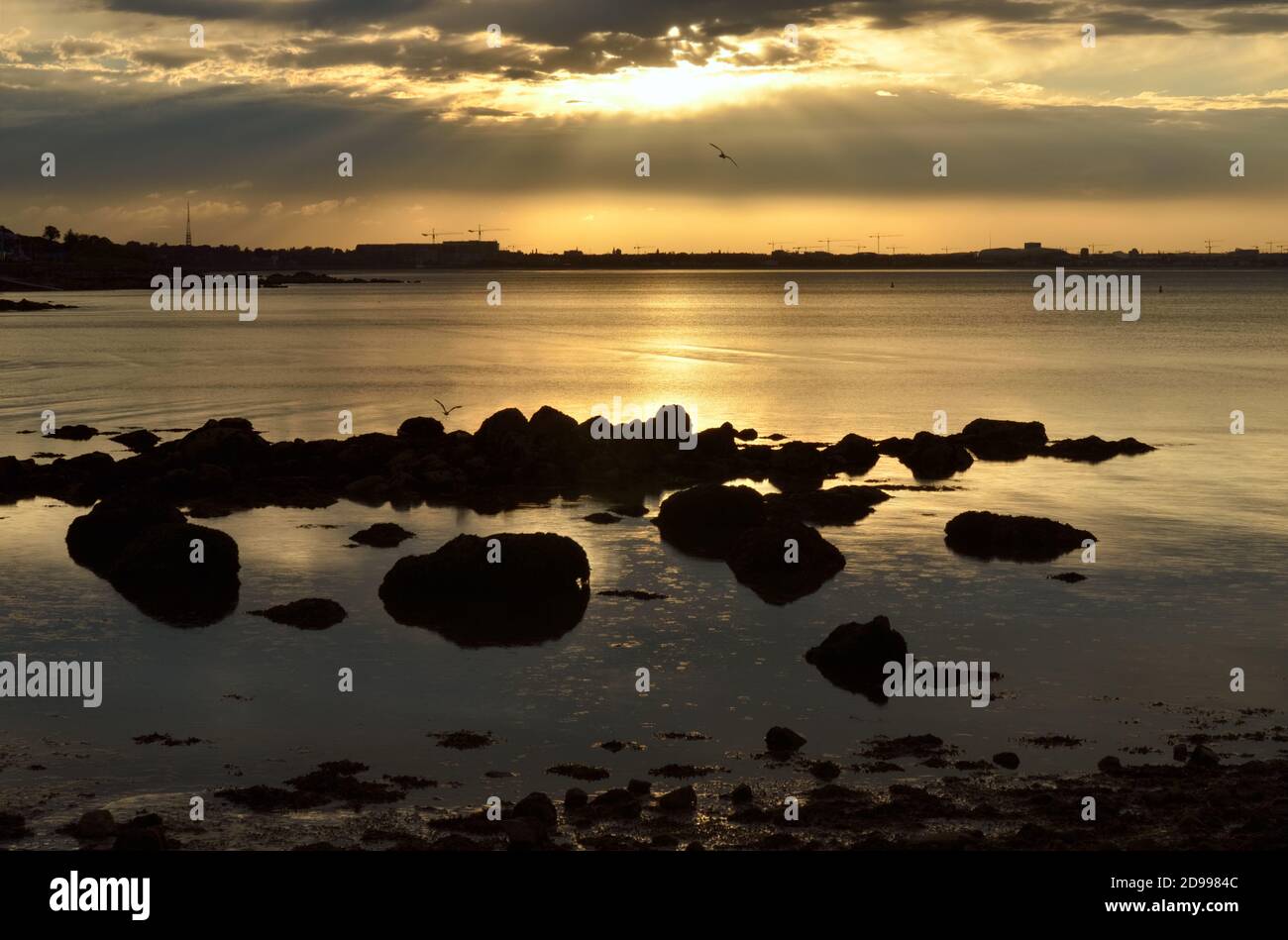Sunset over Dublin bay,in the backround tower cranes on the horizon ...