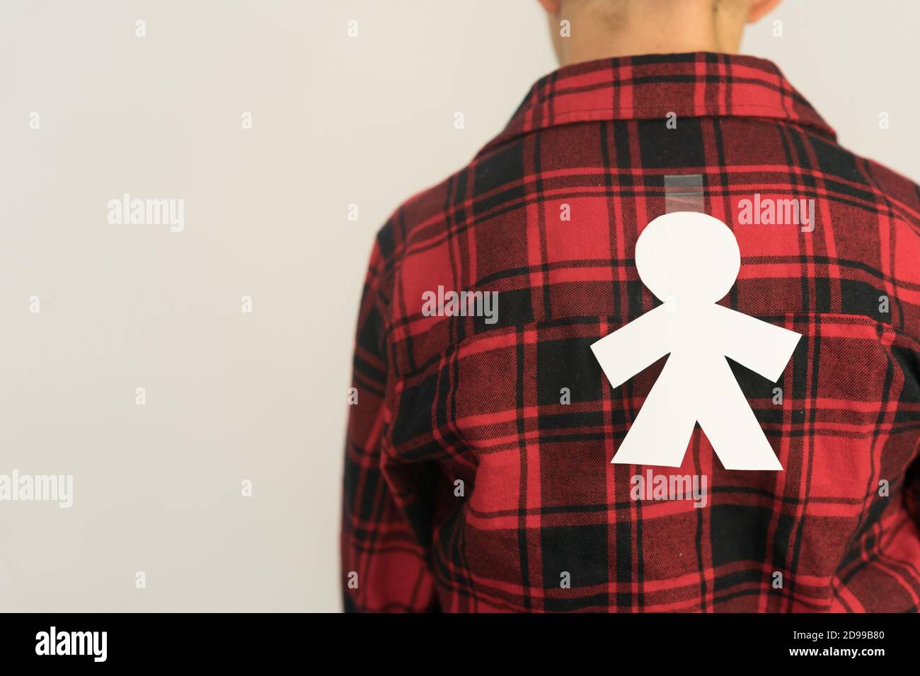 Caucasian child with a paper human attached on his back Stock Photo - Alamy