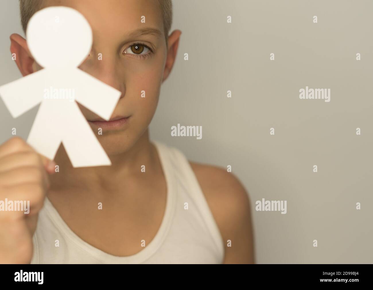 Caucasian boy holding a paper human Stock Photo - Alamy