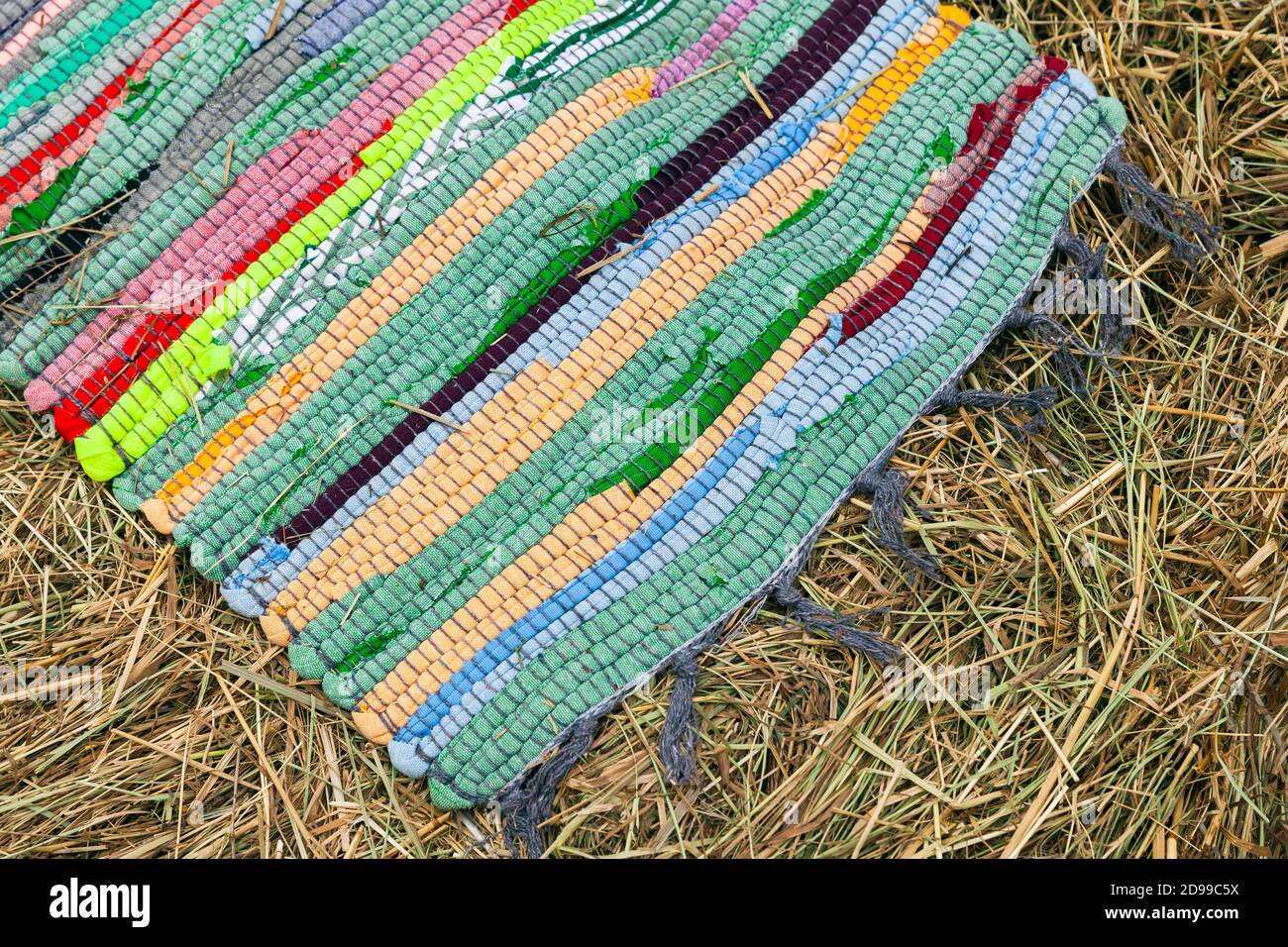 Colorful handmade knitted rug lays on hay, top view Stock Photo - Alamy