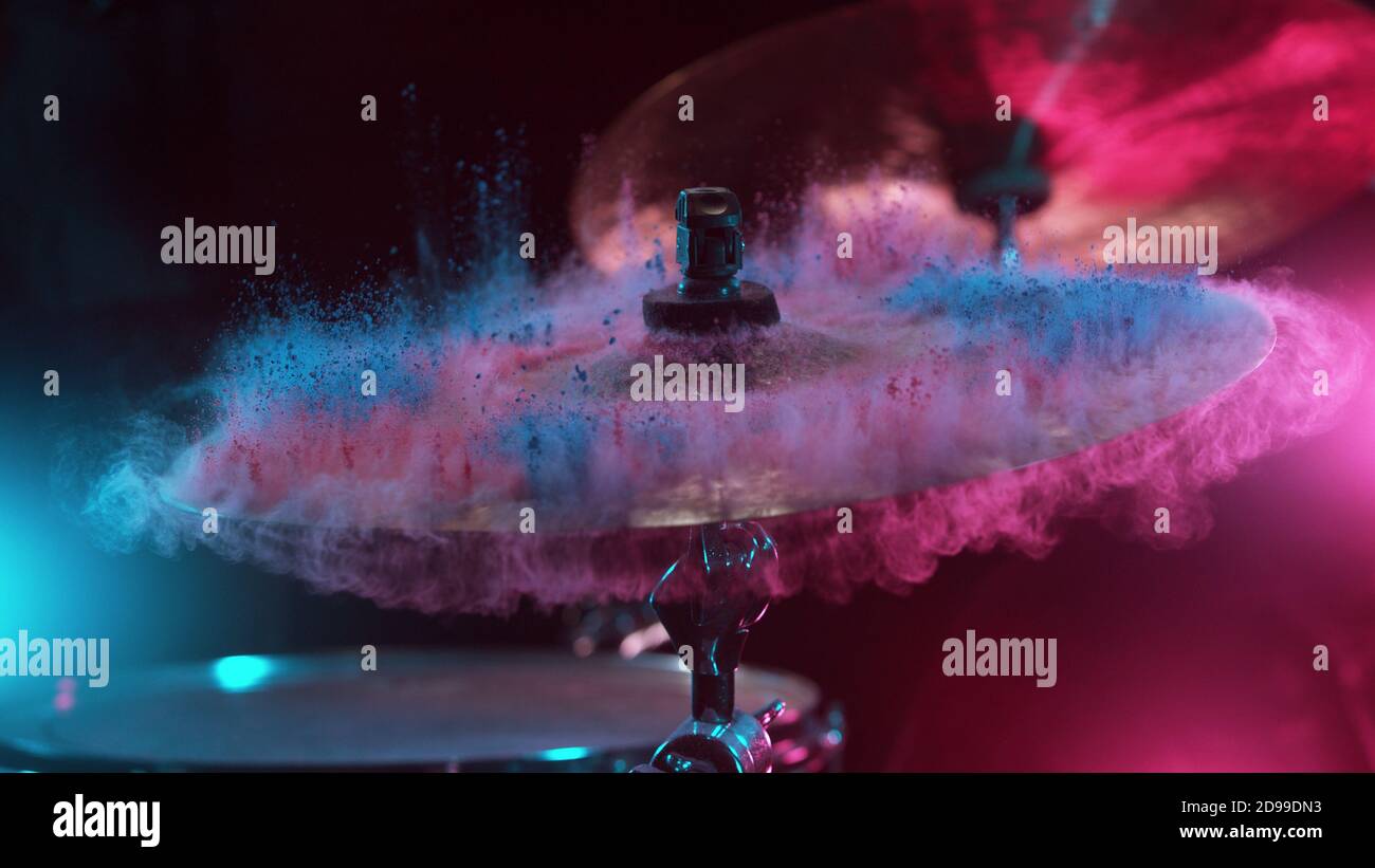 Freeze motion of coloured powder explosion on drum cymbal isolated on ...