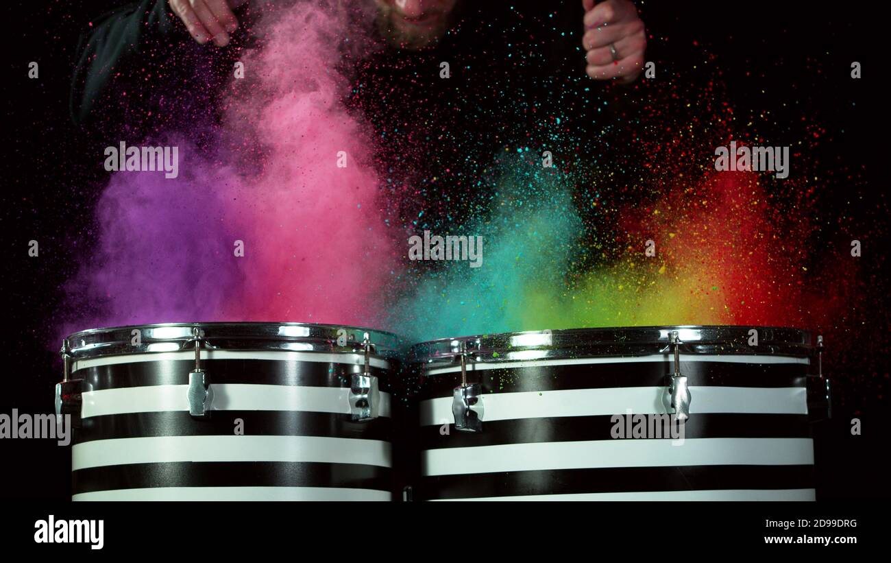 Freeze motion of coloured powder explosion on drums isolated on black ...