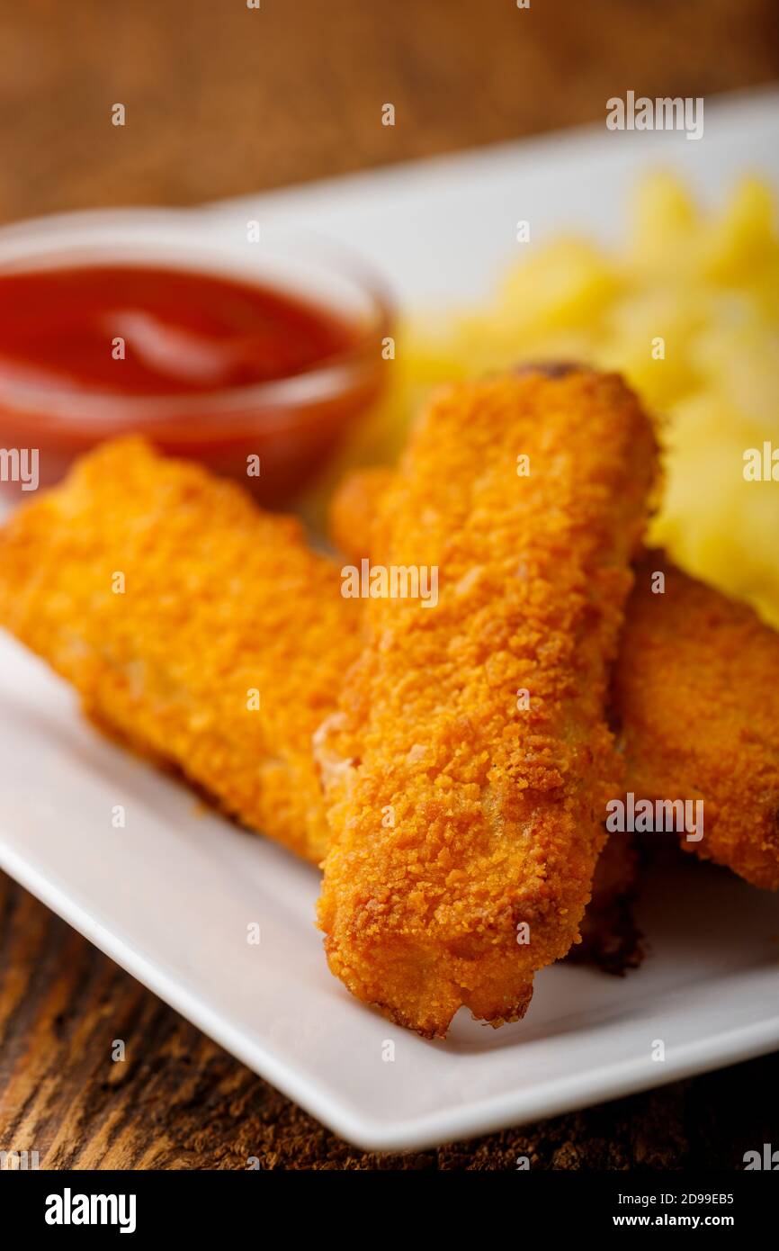 fish fingers with potato salad on a plate Stock Photo - Alamy