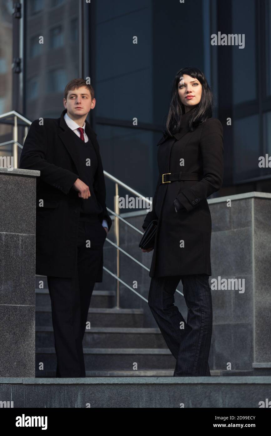 Young fashion business couple on steps at office building Stylish man ...