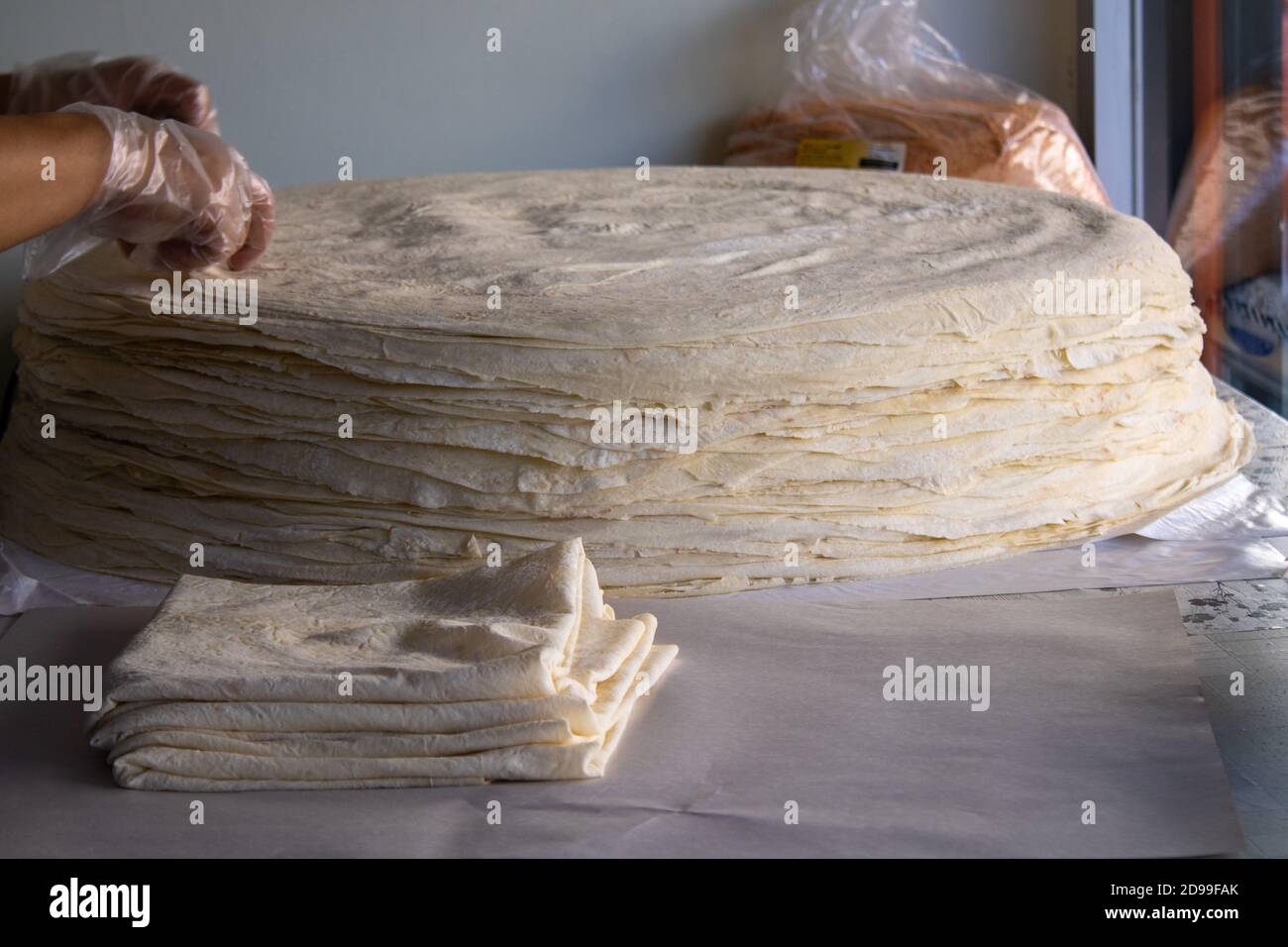 A woman is packing the ready-made dough that she prepared. "Yufka" for ...