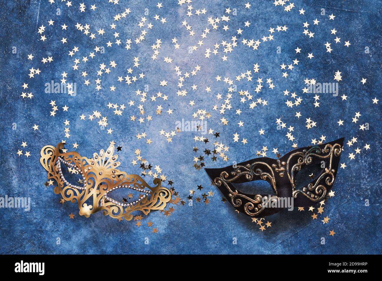 Two carnival mask and golden stars on a blue background. Top view, copy ...