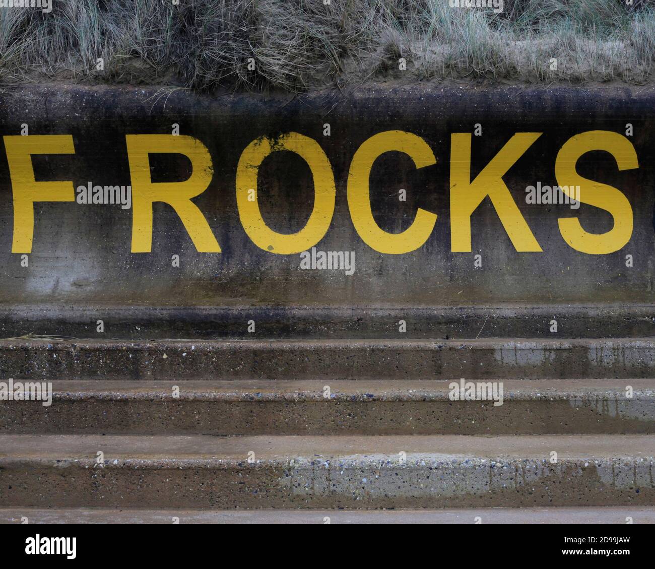 Yellow writing on concrete wall Stock Photo - Alamy