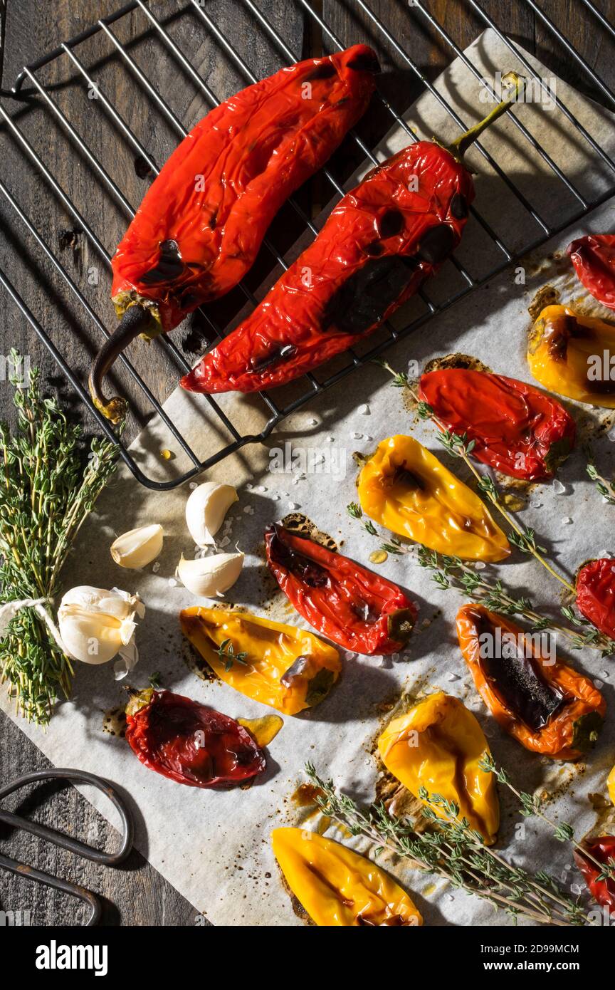Roasted pointed red peppers with garlic and thyme spices on black Stock ...