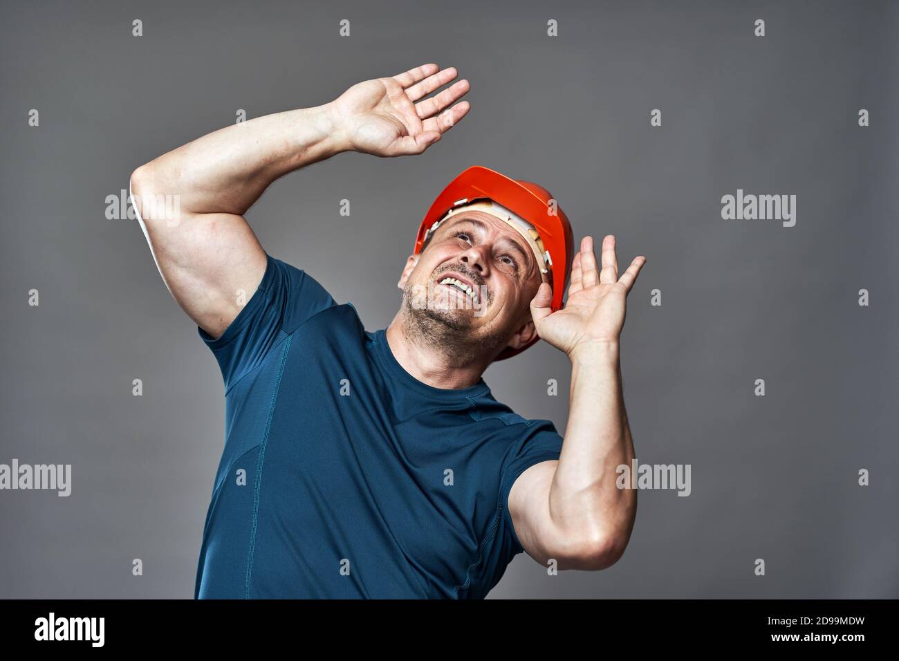 Engineer scared of something about to drop on his head Stock Photo - Alamy