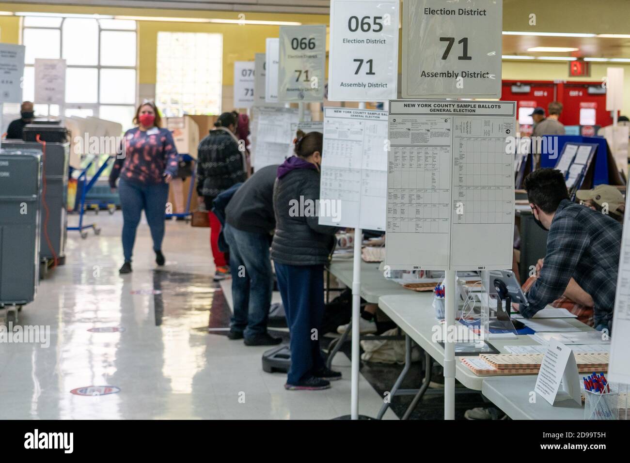 Poll workers wearing face masks check the voters Ids during the 2020 U ...
