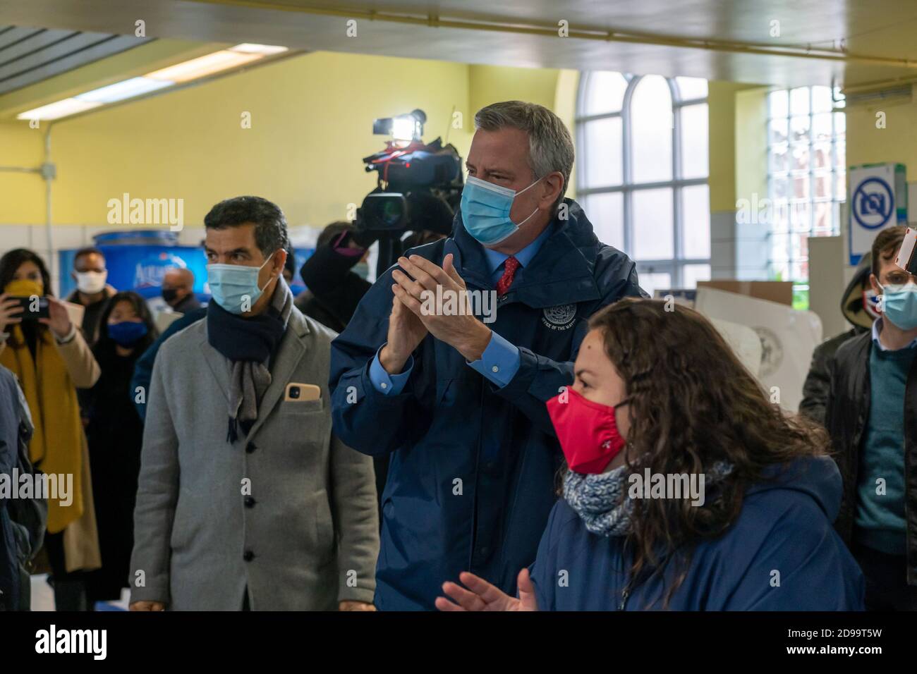 New York City Mayor Bill de Blasio wearing a face mask greets staff ...