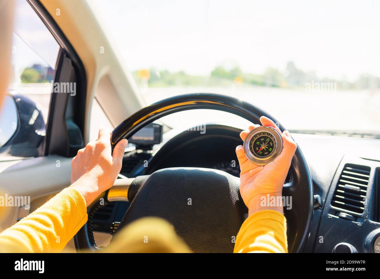 Asian woman inside a car and using compass to navigate while driving ...