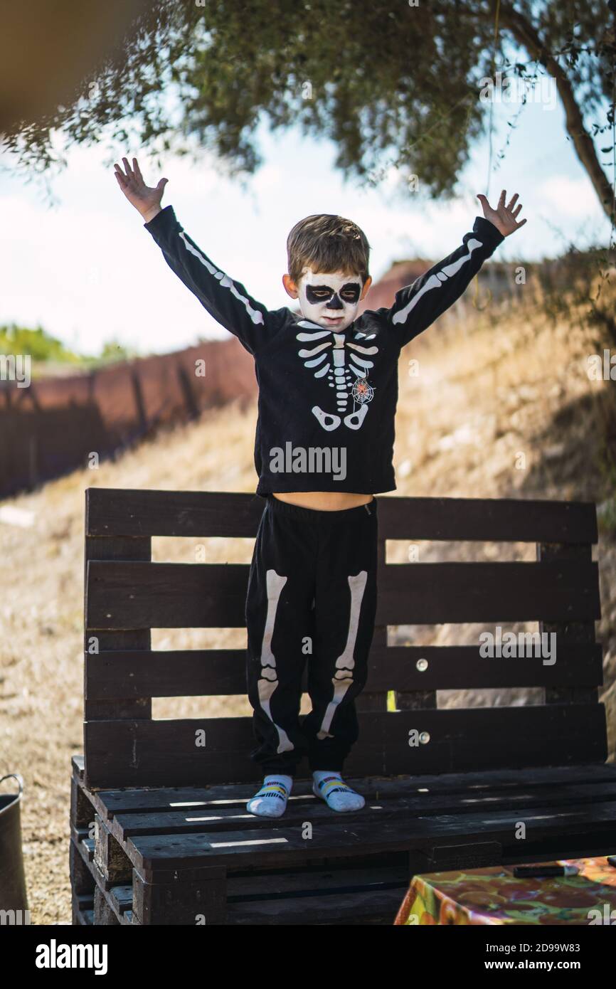 Cute little boy wearing a Halloween skeleton costume standing on a ...