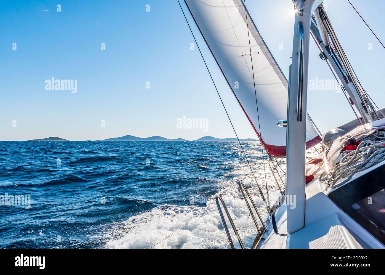 View of the sea, sky, sail and foam waves from the yacht moving forward ...