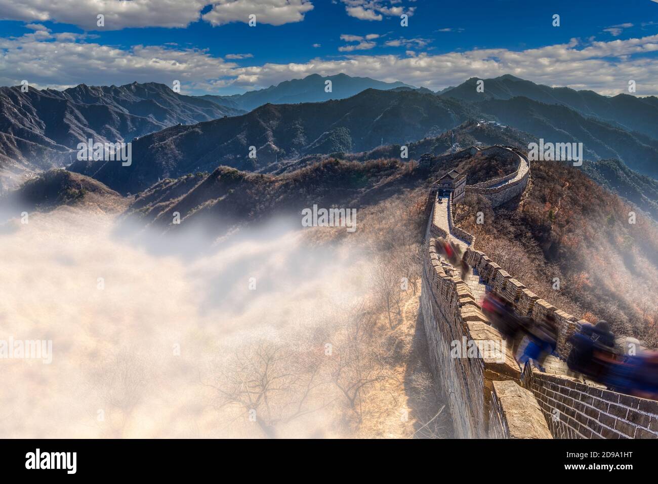 The great wall of china bathed in morning sun with moving fog and ...