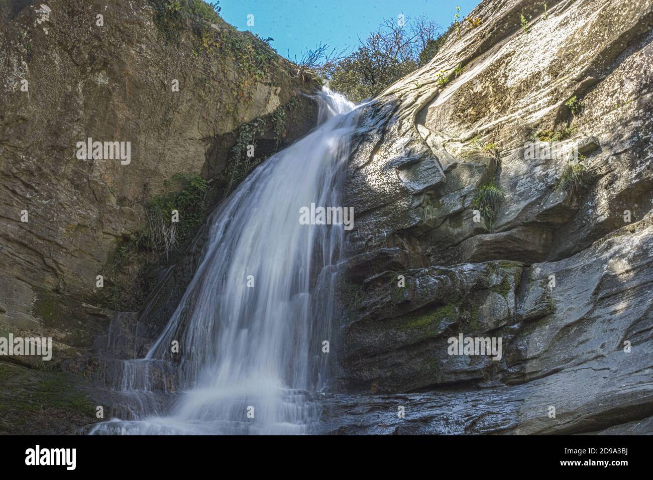 La Foradada waterfall under the sunlight and a blue sky in Spain Stock ...