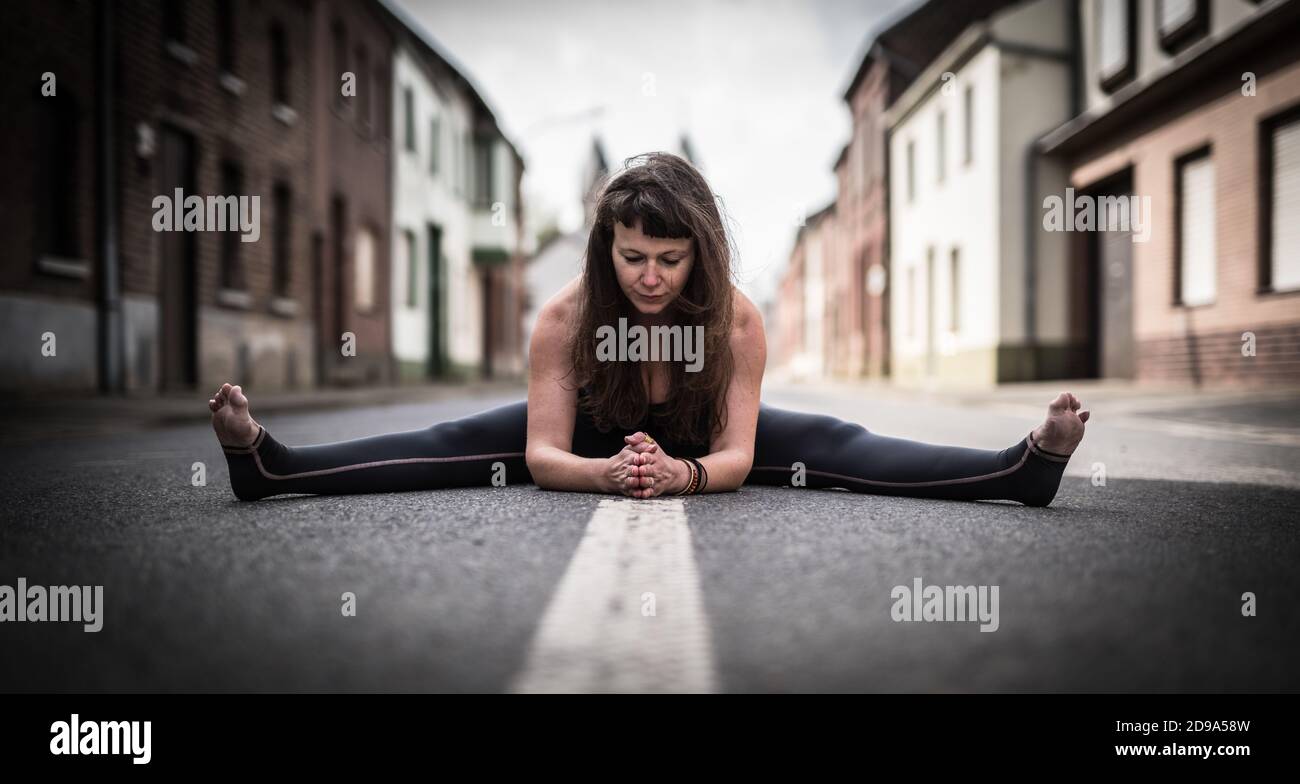 Wide-angle shot of a German woman doing yoga stretching in the middle ...