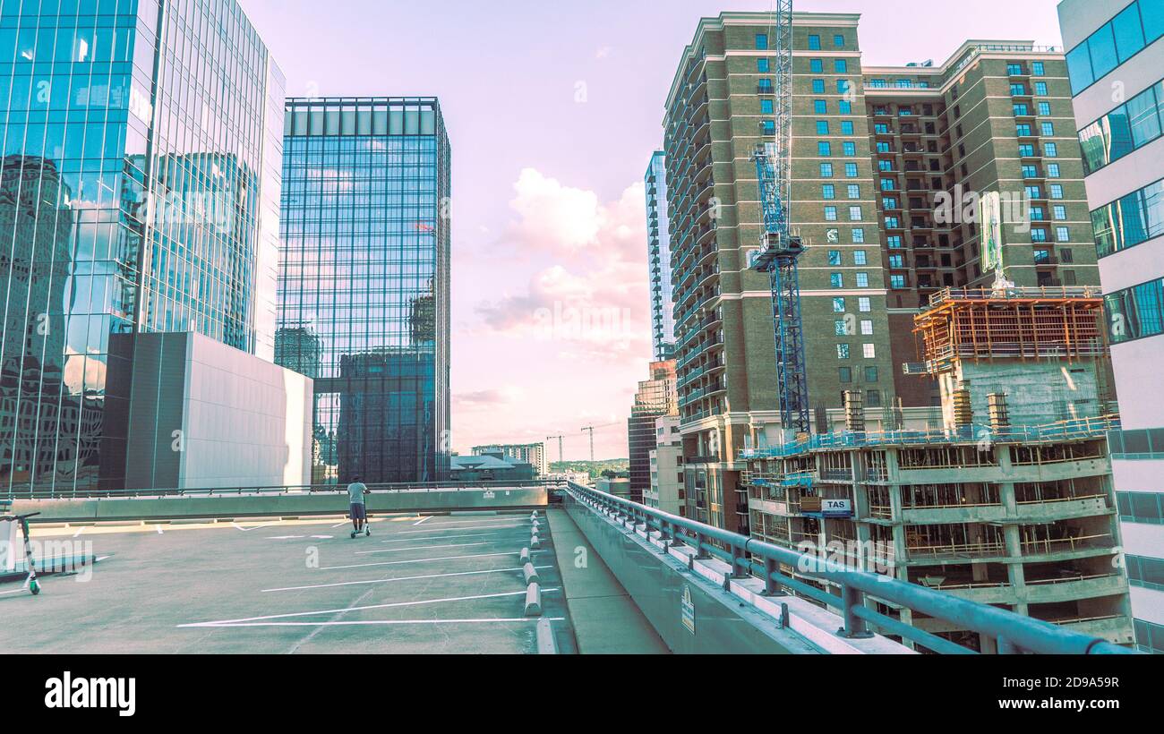 Unfinished building surrounded by modern buildings with glass walls ...