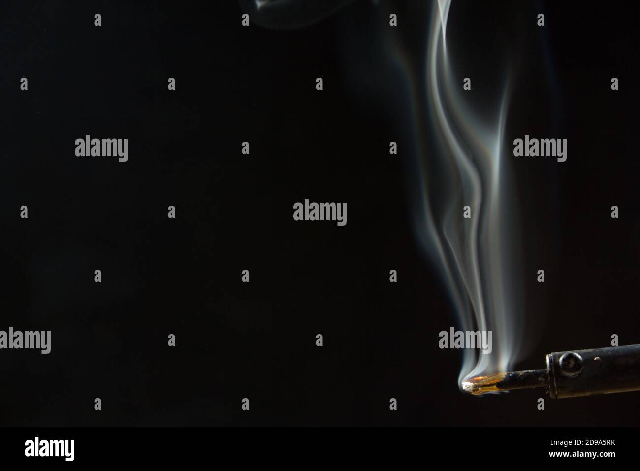 Heated soldering iron with smoke from the sting of burning rosin ...