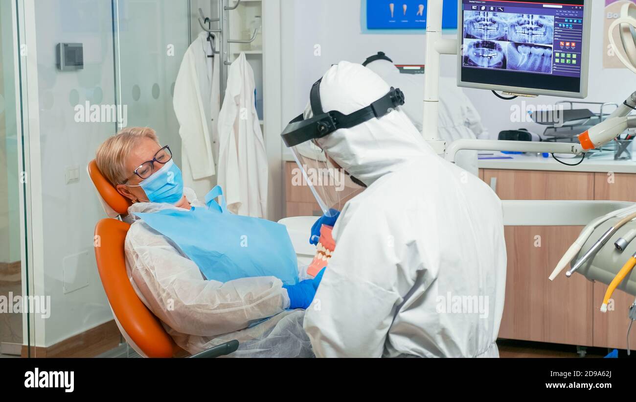 Dentist doctor in coverall showing the correct dental hygiene using ...