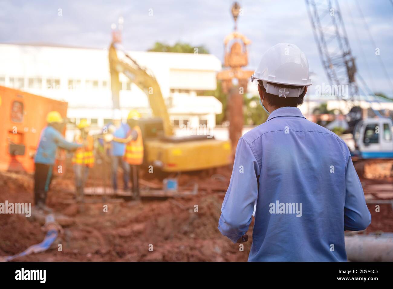 Engineer technician watching team of workers at construction site ...