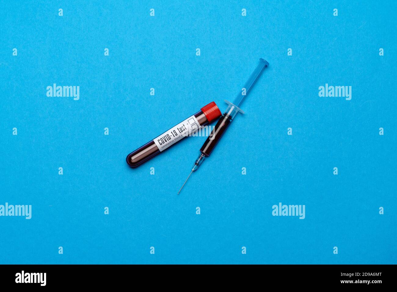 Syringe And Plastic Test Tube With Blood Sample over blue background ...