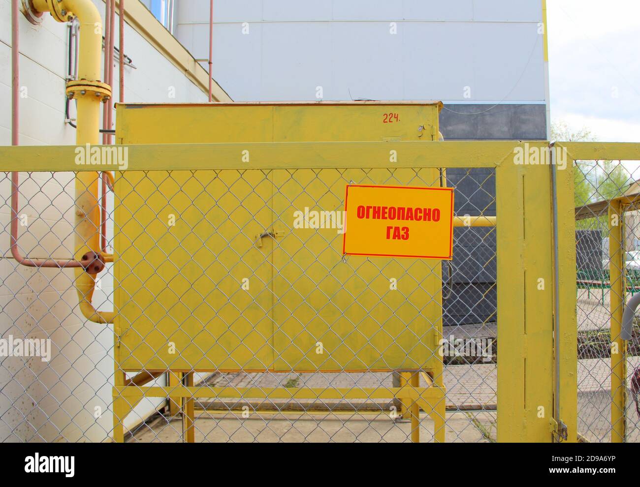 A yellow plaque that reads 'Fire Gas' on a fence made of metal mesh ...