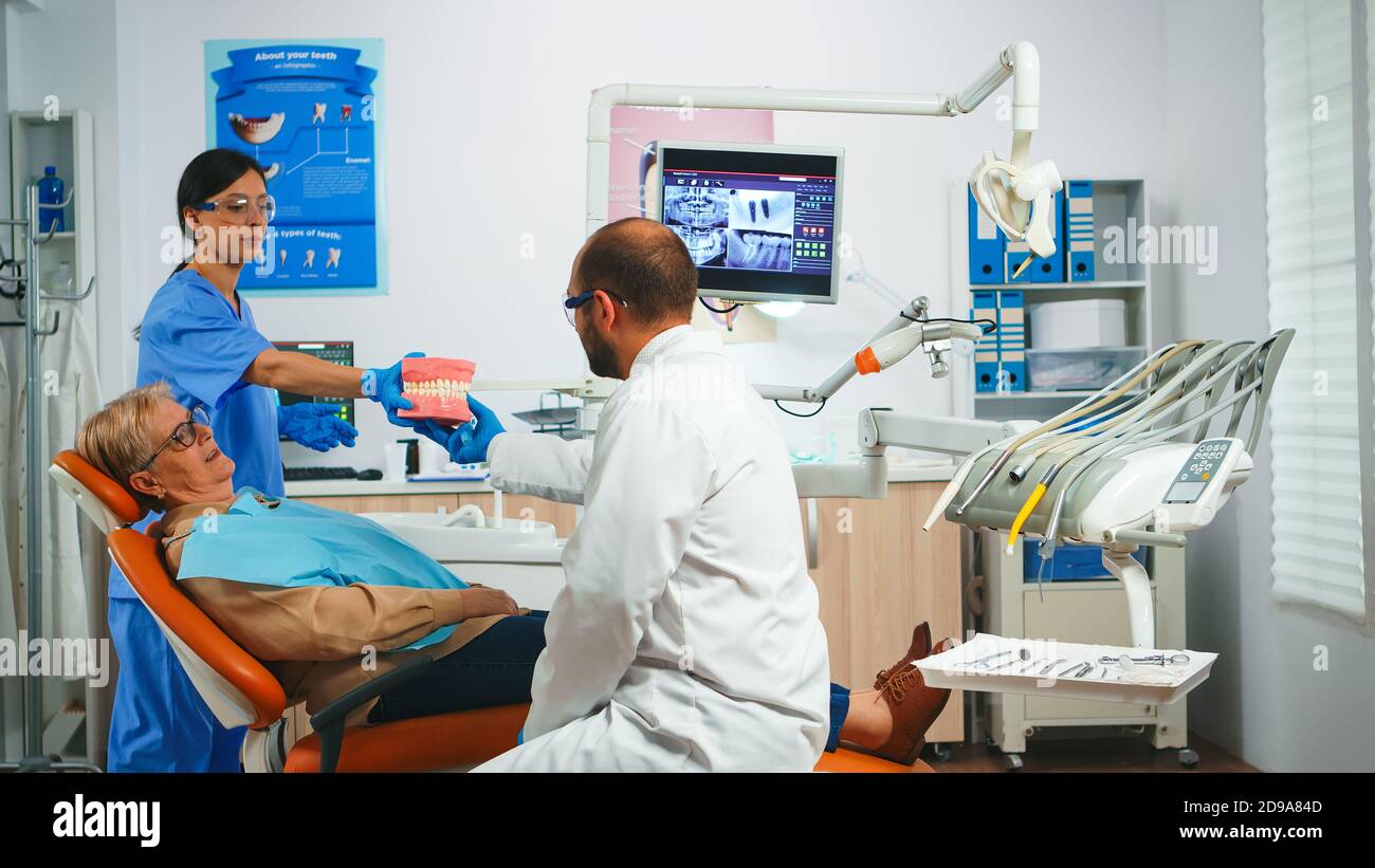 Stomatologist explaining proper dental hygiene using presentation teeth ...