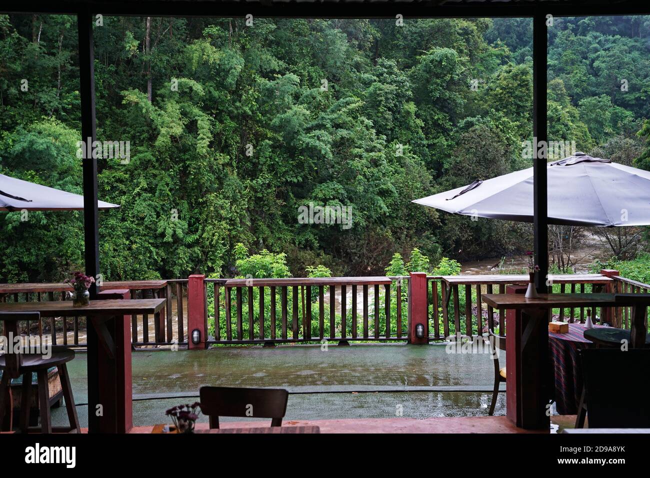 Wooden outdoor patio terrace and balcony lounge facing natural stream ...