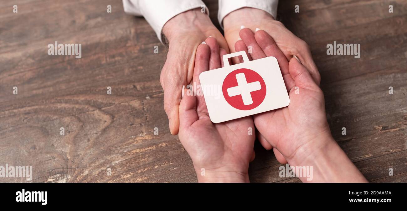 Hands holding a paper medical briefcase; Symbol of health insurance ...