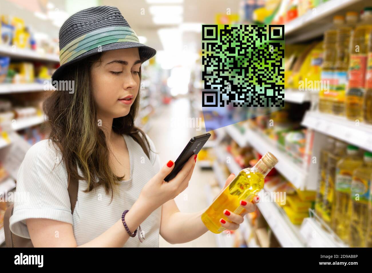 Young beautiful woman chooses a bottle of oil in the supermarket and ...