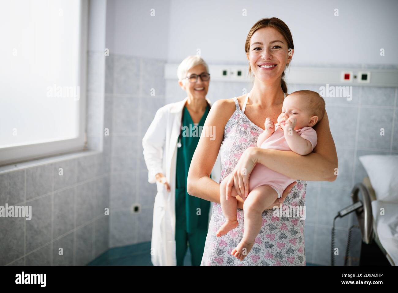Pediatrician with mother and baby on examination in hospital ...