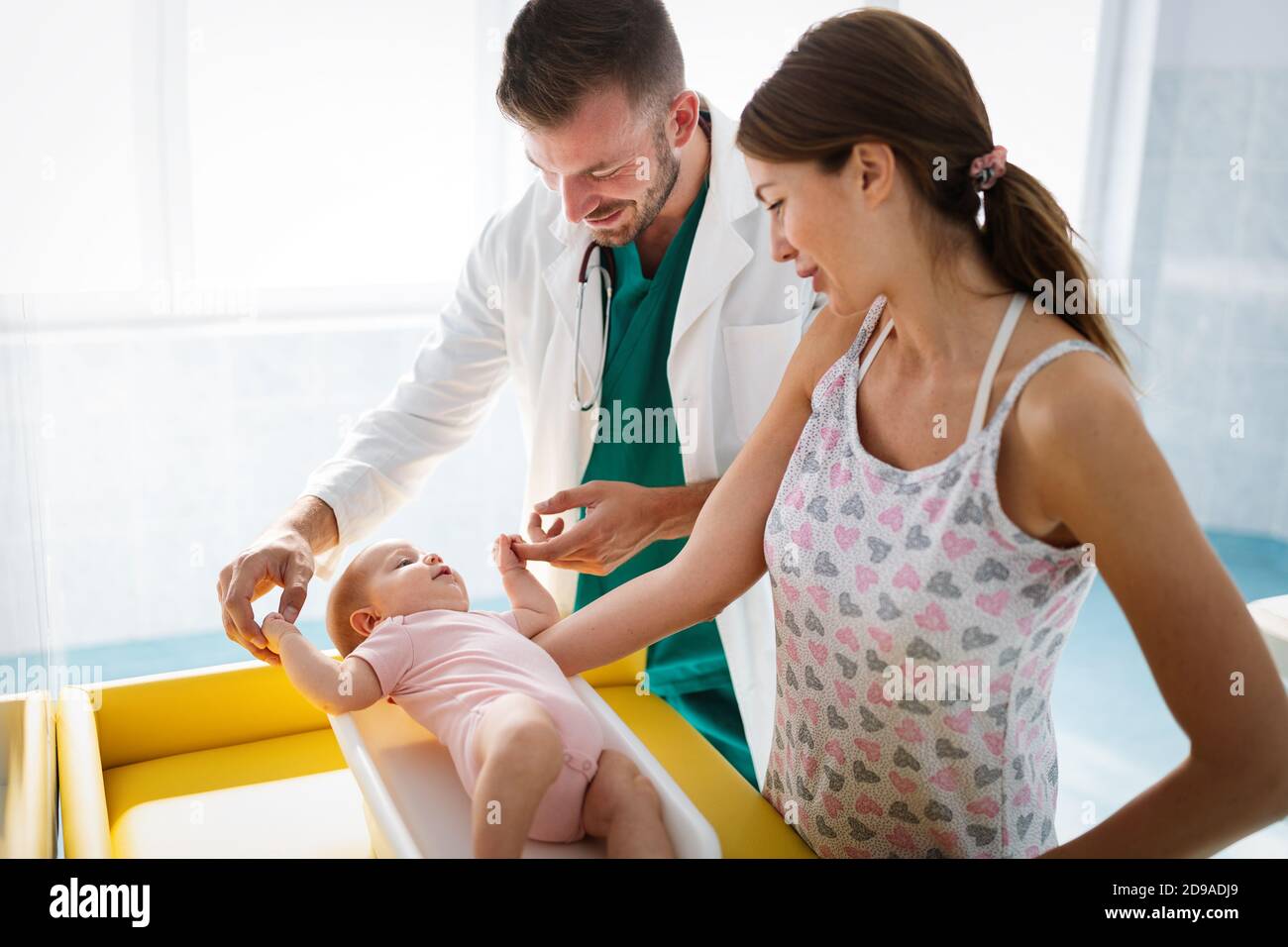 Pediatrician with mother and baby on examination in hospital ...