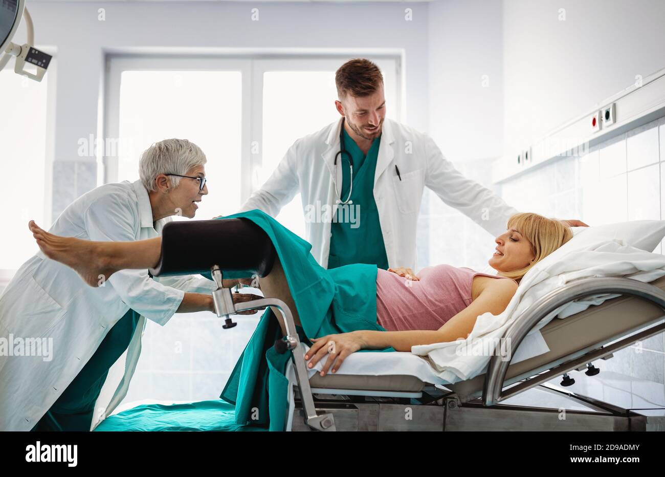 Medical team, obstetrician examining pregnant young woman in hospital ...