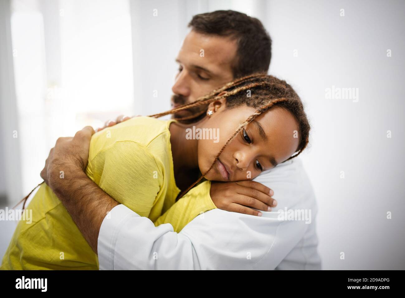 Doctor comforting, supporting a worried sad girl kid in hospital Stock ...