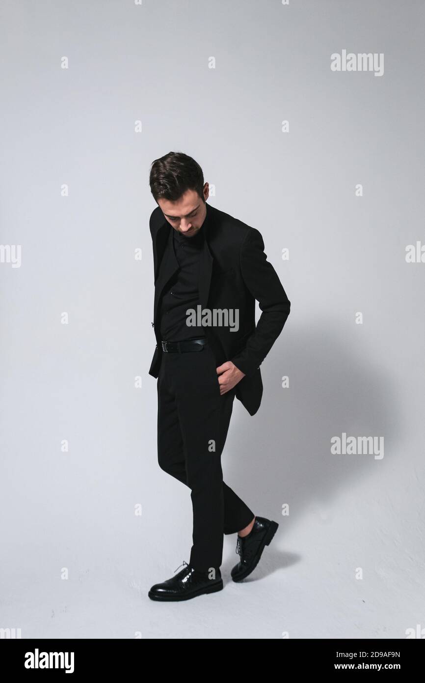 Studio portrait of a young caucasian man in a black blazer, looking ...