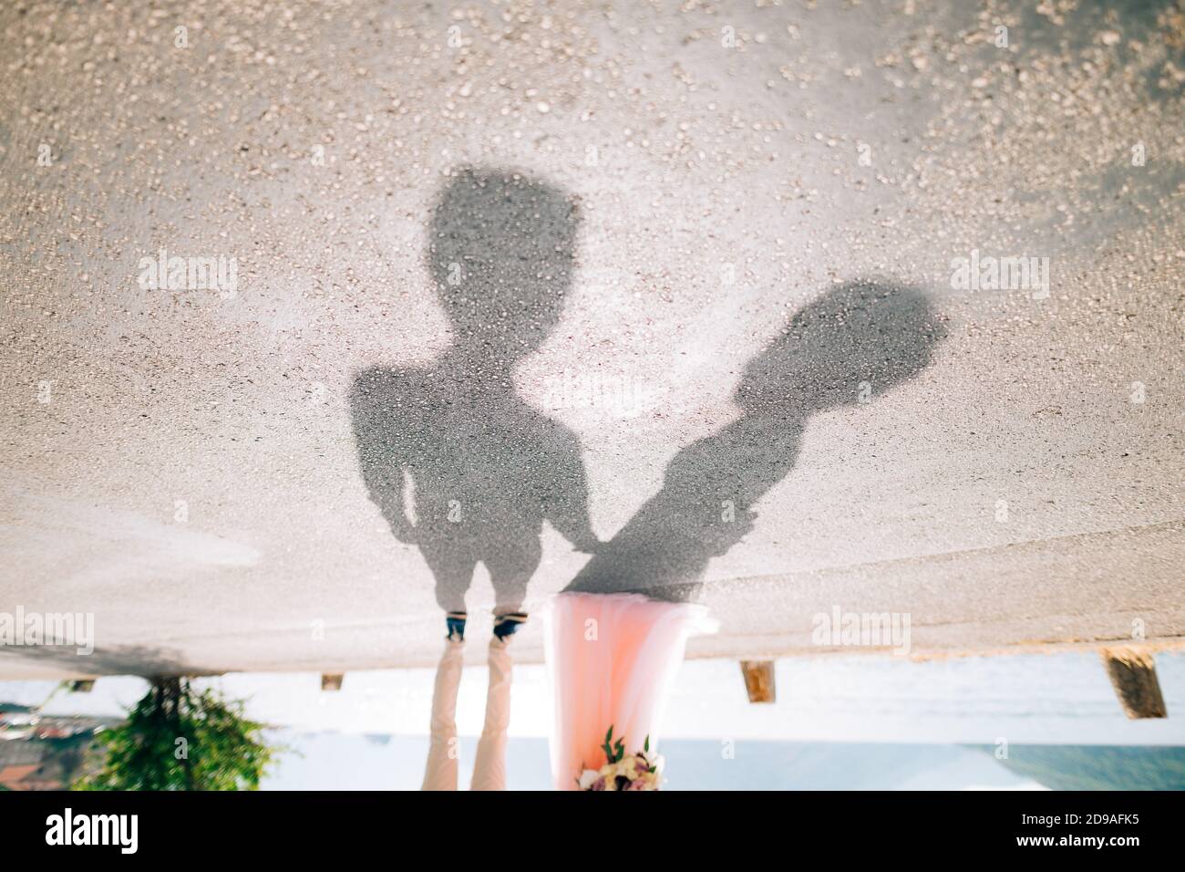 shadows of the bride and groom, that look at each other and hold hands ...
