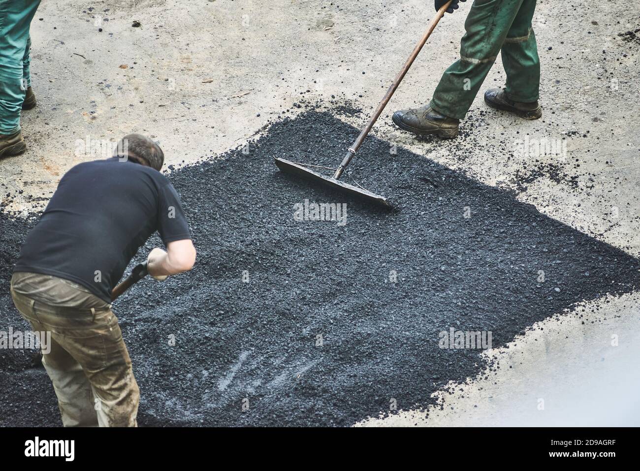 workers smooth new asphalt with trowel Stock Photo - Alamy