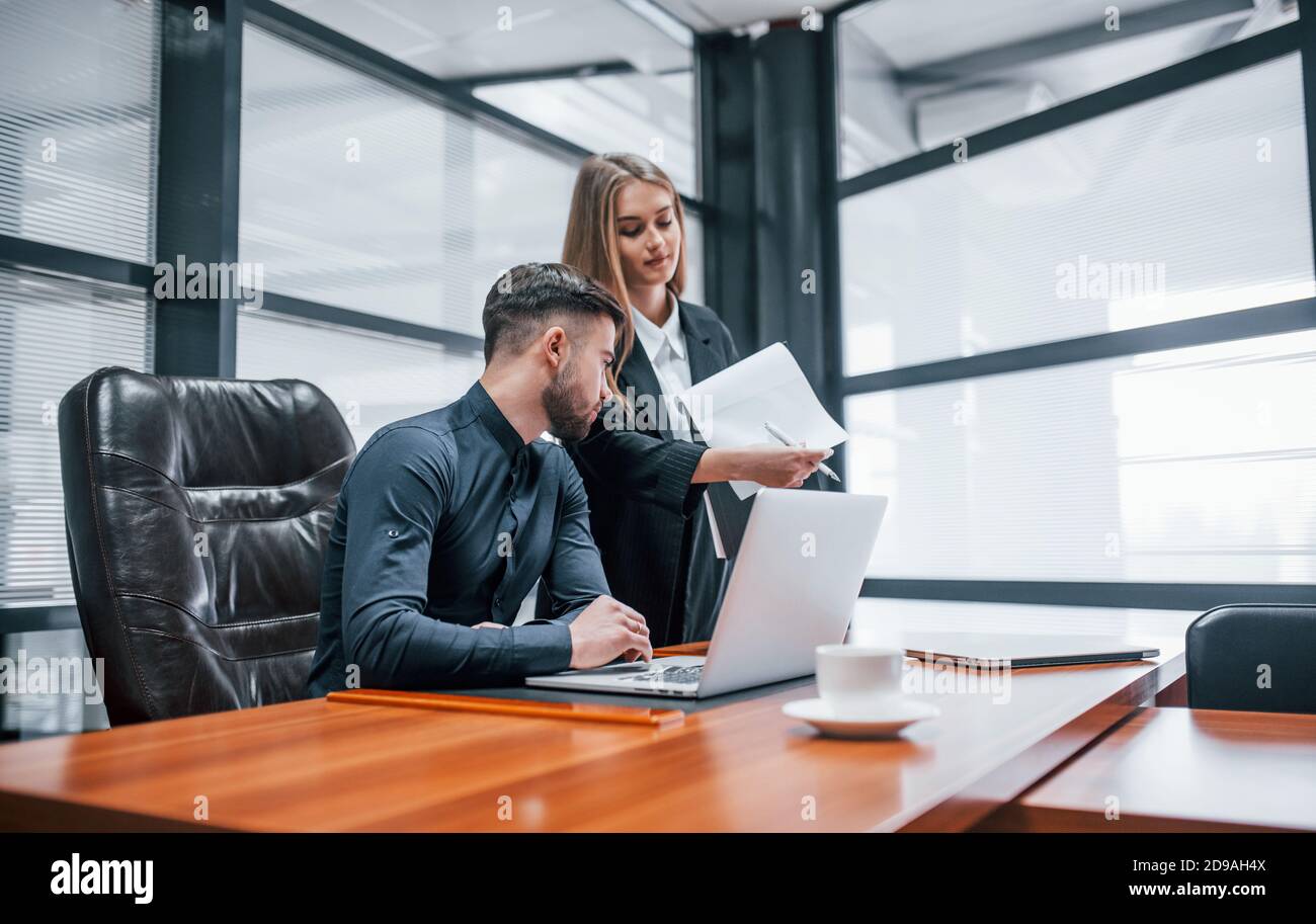 Woman and man in formal clothes working together indoors in the office ...