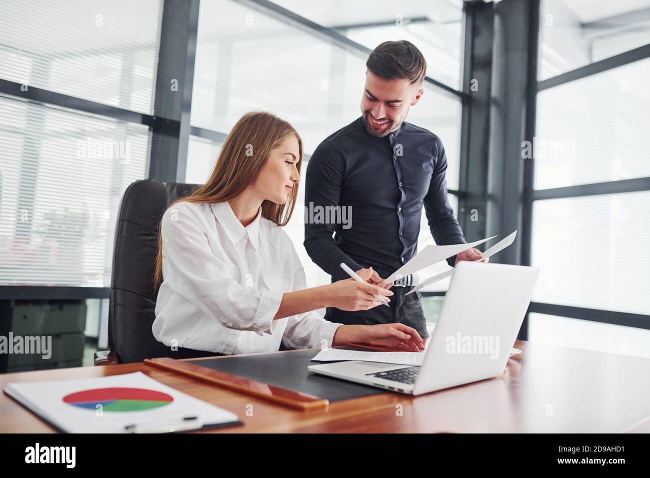 Woman and man in formal clothes working together indoors in the office ...