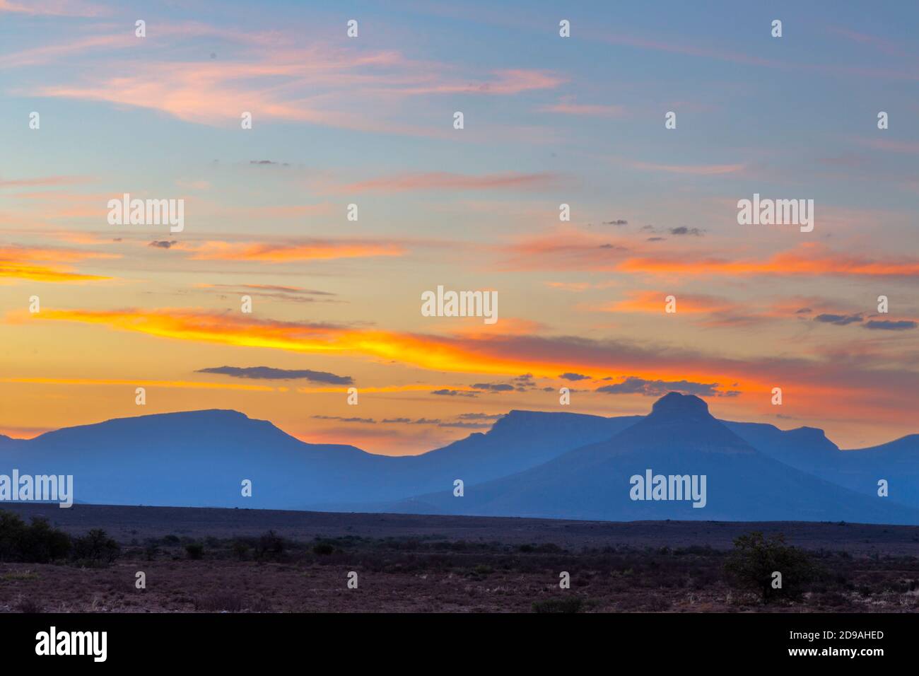 Blue mountains and yellow clouds at sunset Stock Photo - Alamy