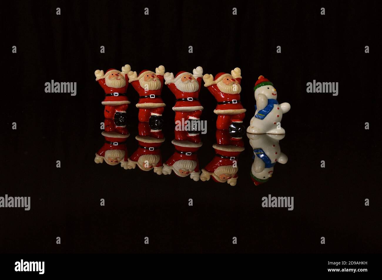 A christmas display of a row of Christmas Santas and a snowman on a ...