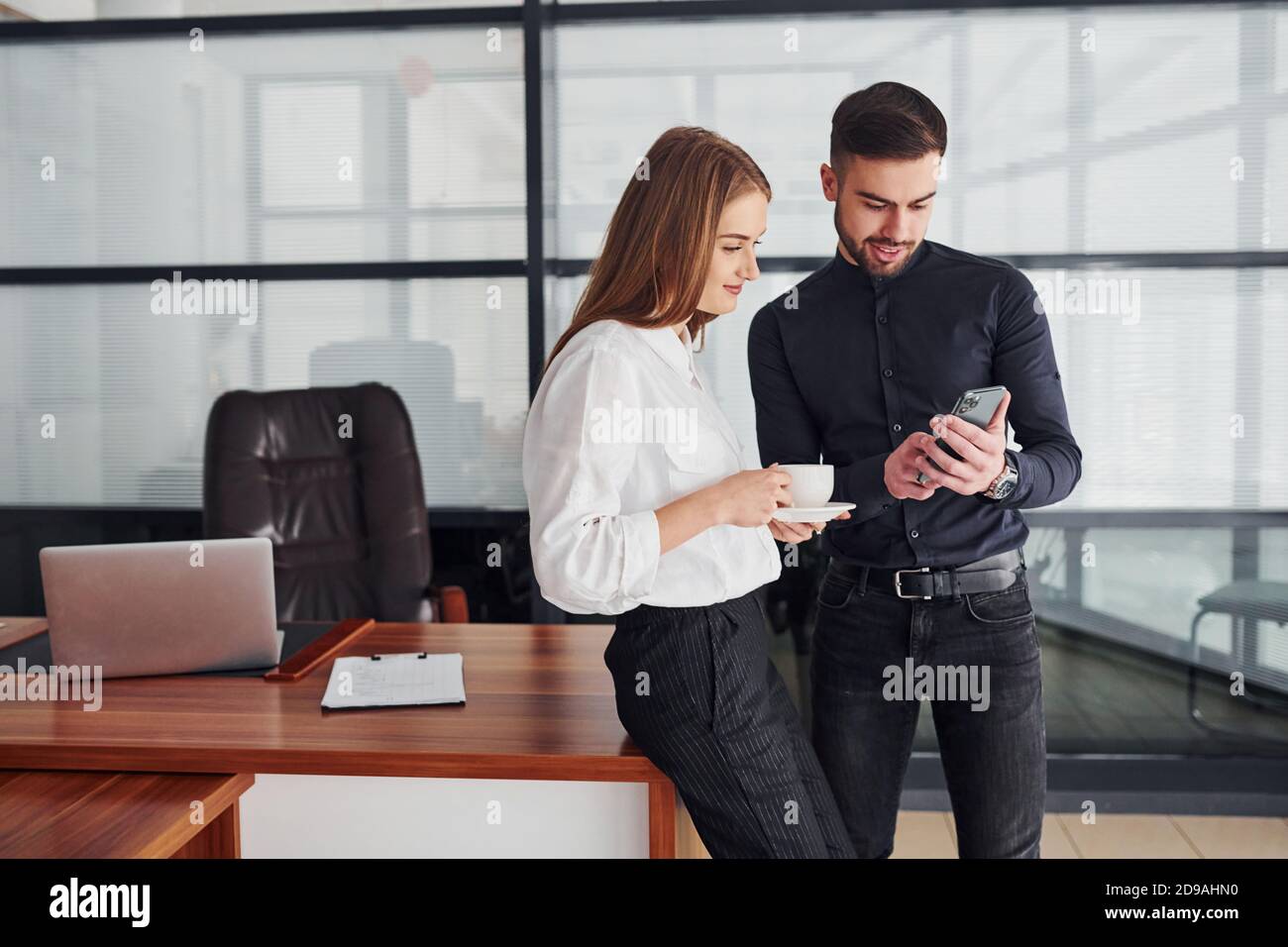 Woman and man in formal clothes with documents talking to each other in ...