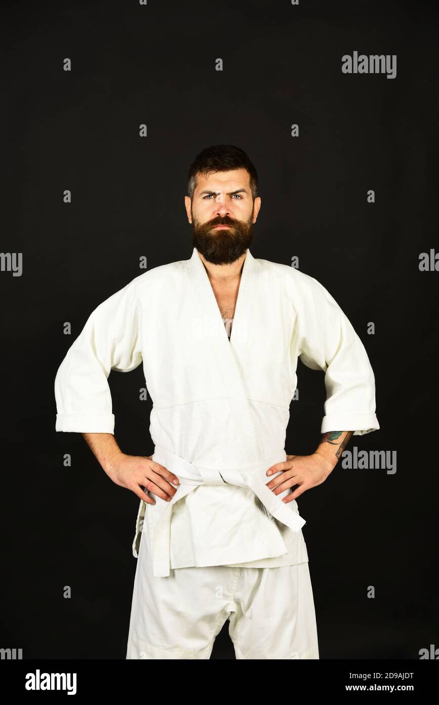 Karate man with strict face in uniform. Jiu Jitsu master poses holding ...