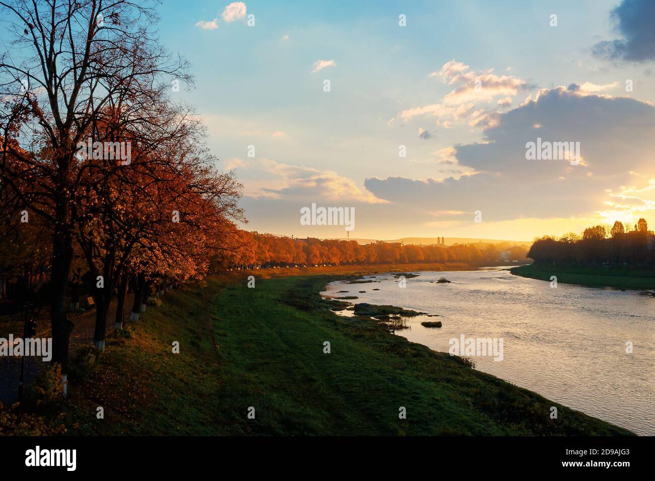river uzh at sunrise. beautiful cityscape autumn scenery. linden alley ...