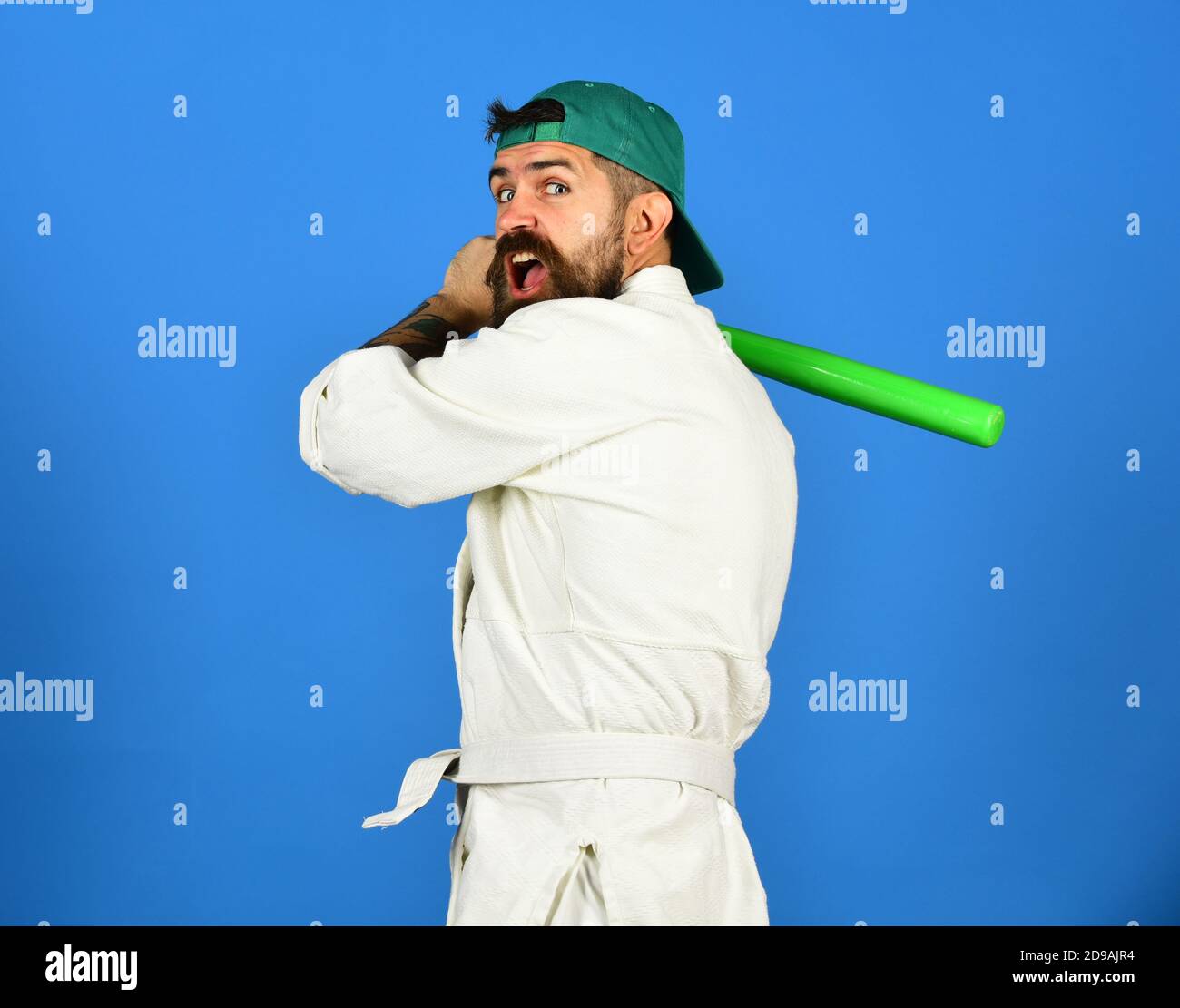 Athlete gets ready to fight. Man with beard in white kimono and green ...