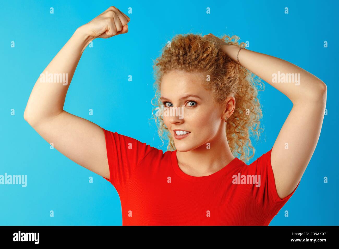 Funny young blonde woman showing how strong her hands are Stock Photo - Alamy