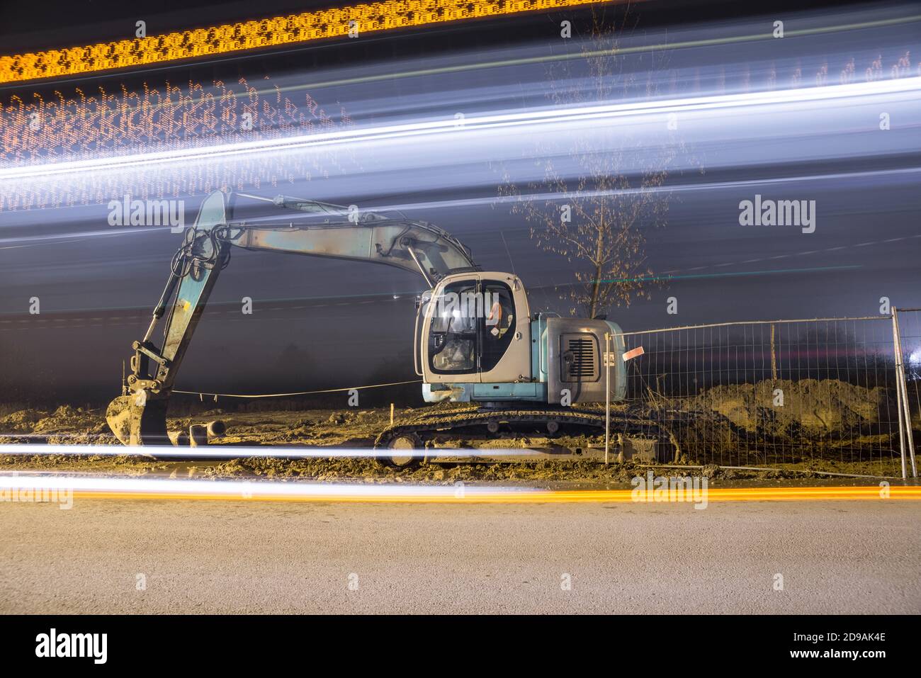 Blue excavator digger working at night on the street Stock Photo - Alamy